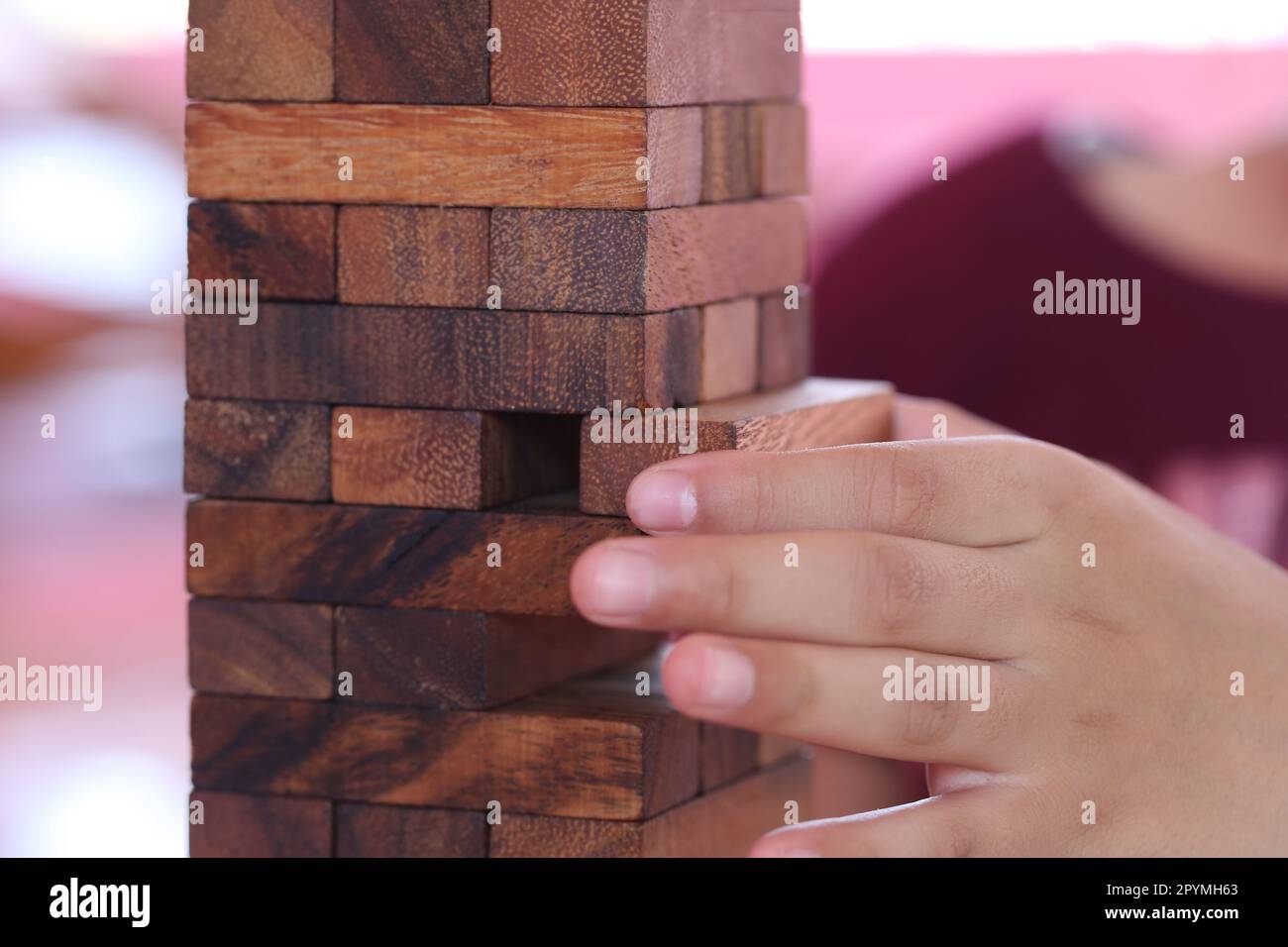 Wooden puzzle game align vertically and finger of child in toy concept ...