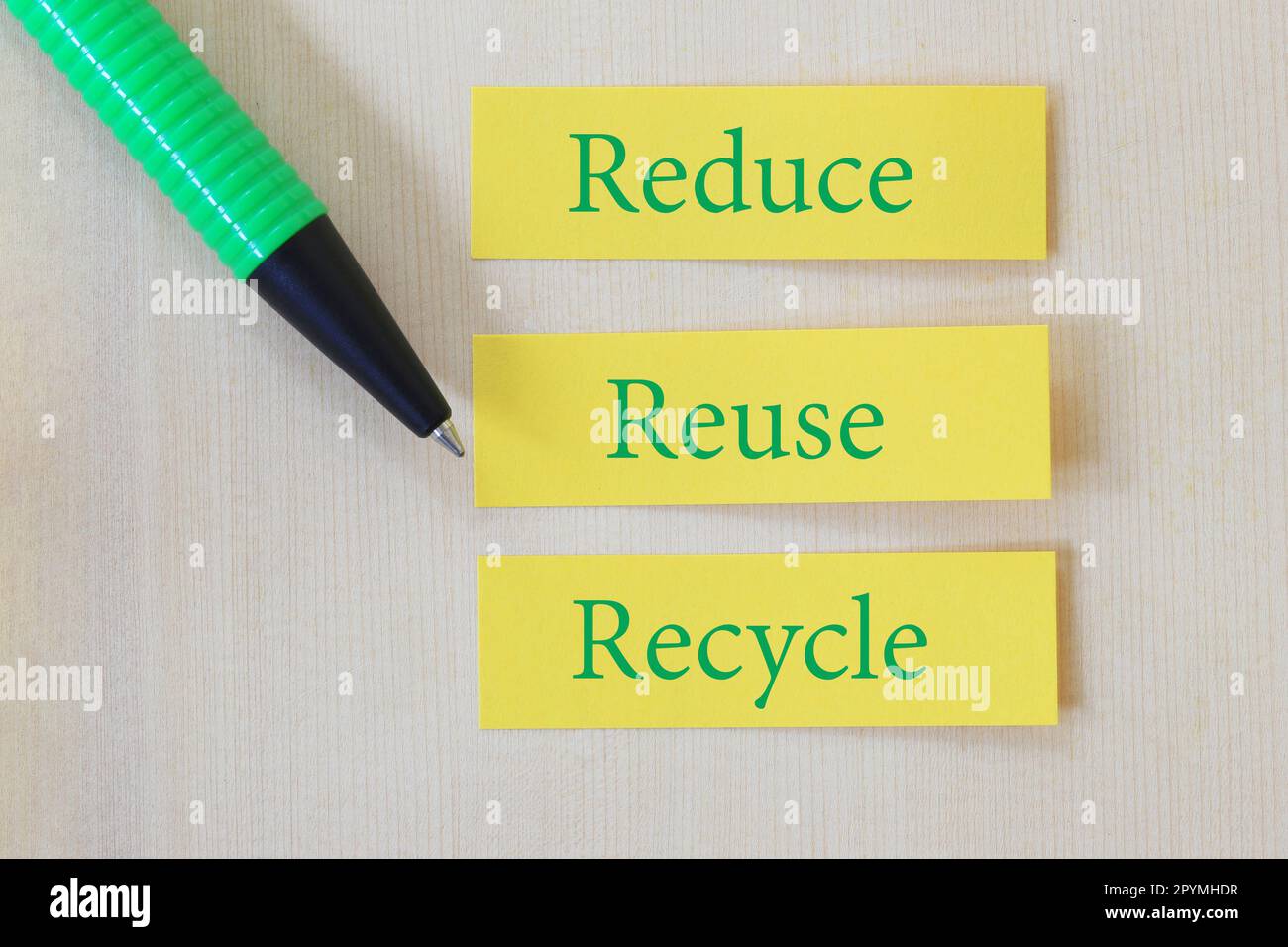 Green Pen pointing Text on yellow paper note with the words of Reduce ...
