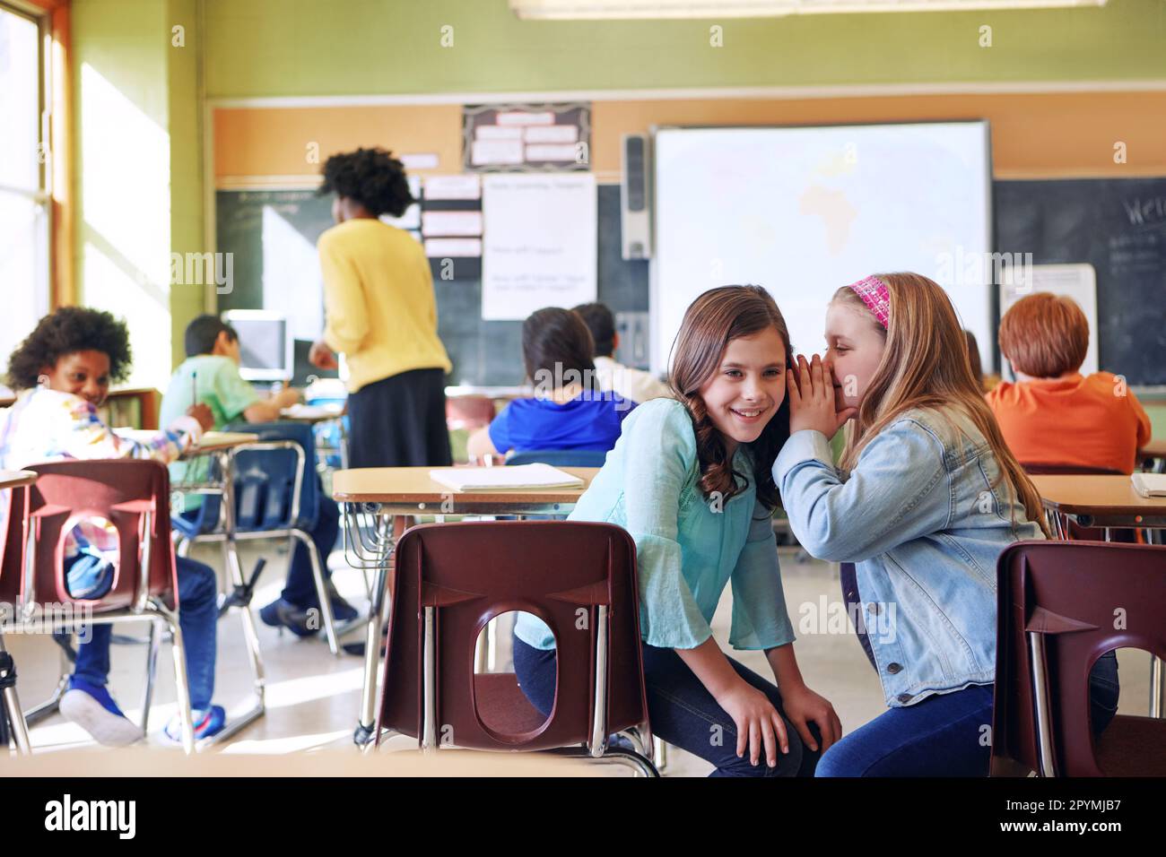 I know something you dont know...a student whispering in a friends ear ...