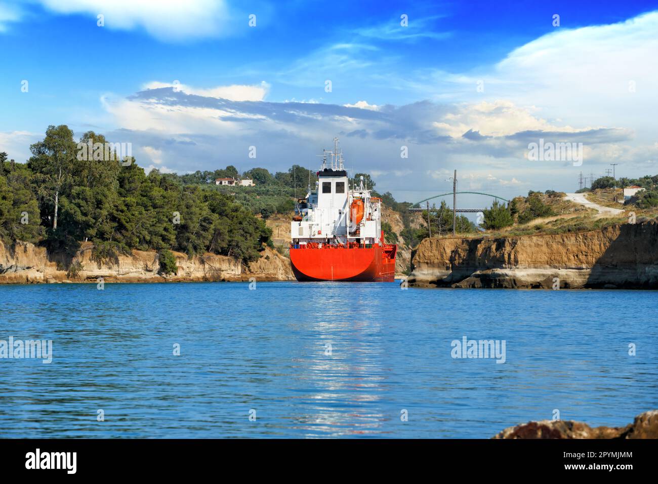 Cargo ship sails between the rocks of the Corinth Canal. Scenic summer ...