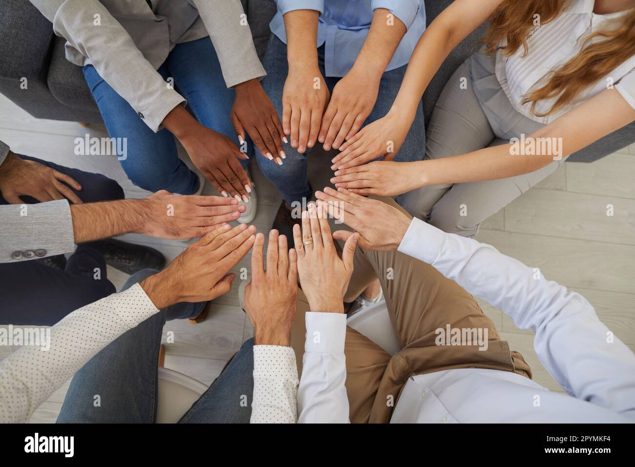 Team of multiracial business people joining their hands to show concept of teamwork and support ...