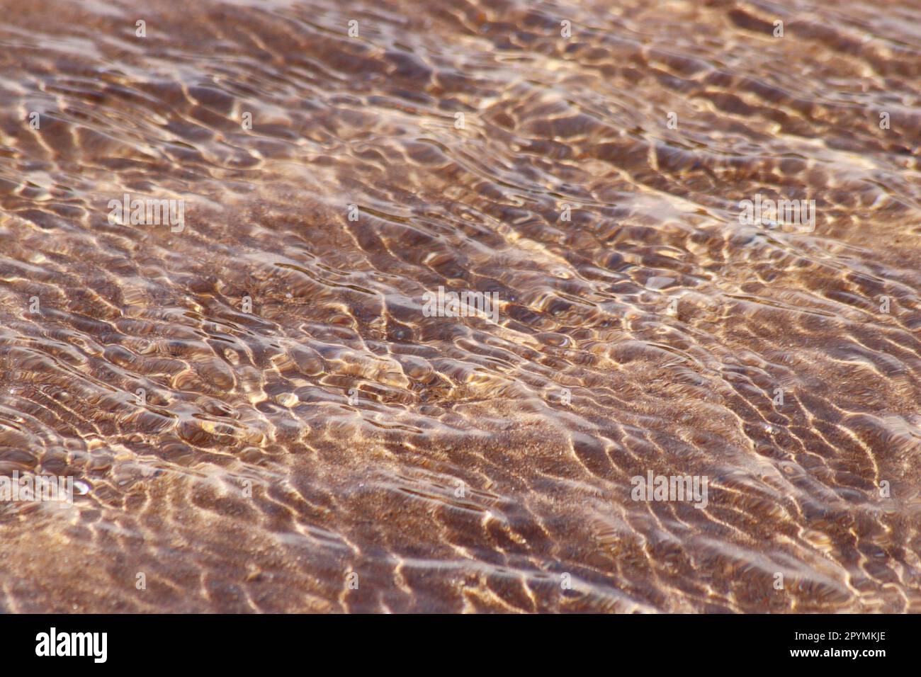 Ripples in sea water on beach Stock Photo - Alamy