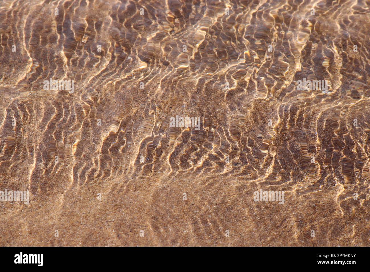 Ripples in sea water on beach Stock Photo - Alamy
