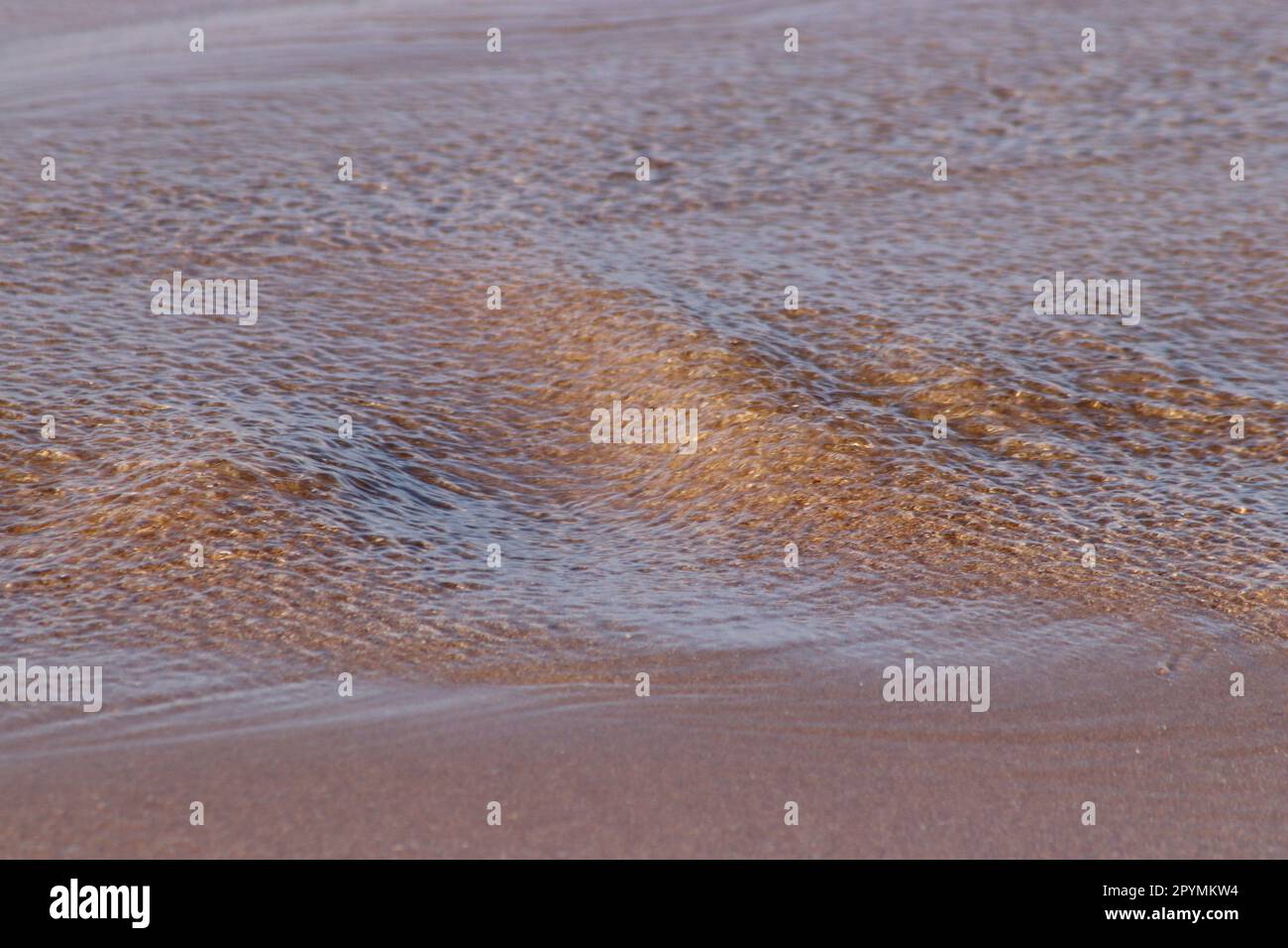 Ripples in sea water on beach Stock Photo - Alamy