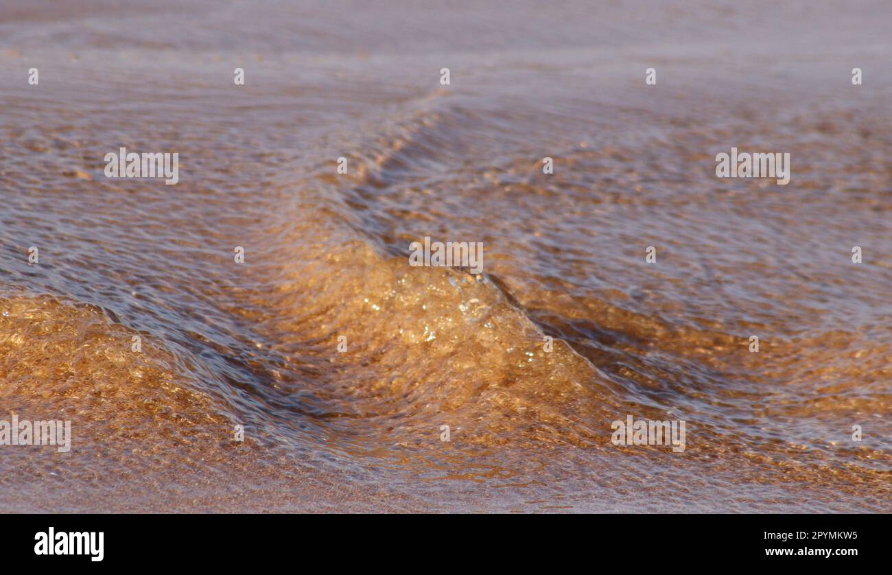 Ripples in sea water on beach Stock Photo - Alamy