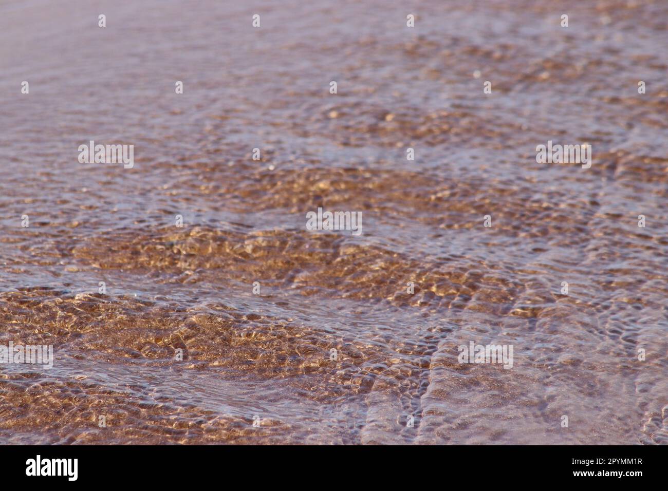 Ripples in sea water on beach Stock Photo - Alamy