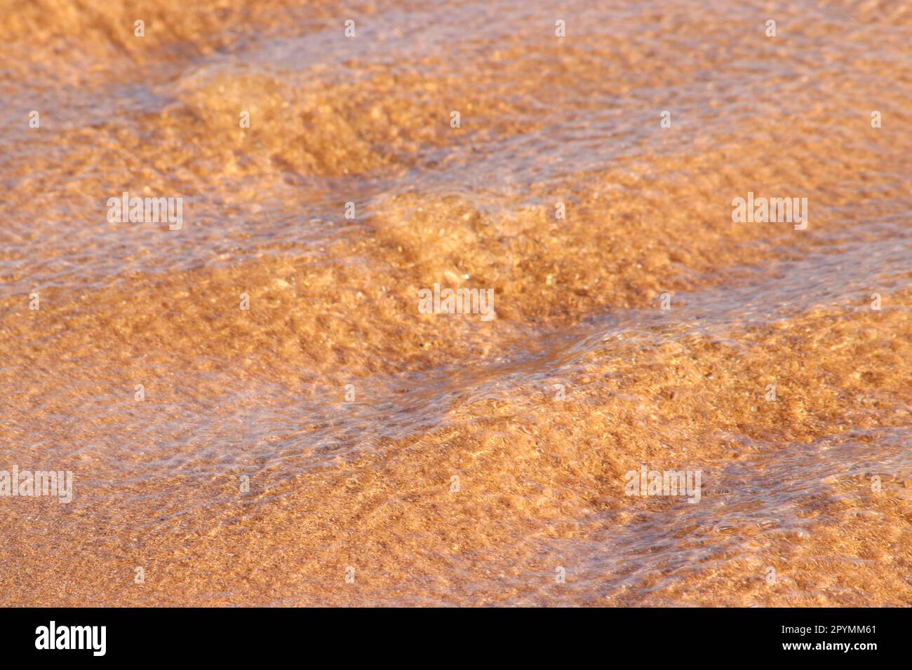 Ripples in sea water on beach Stock Photo - Alamy