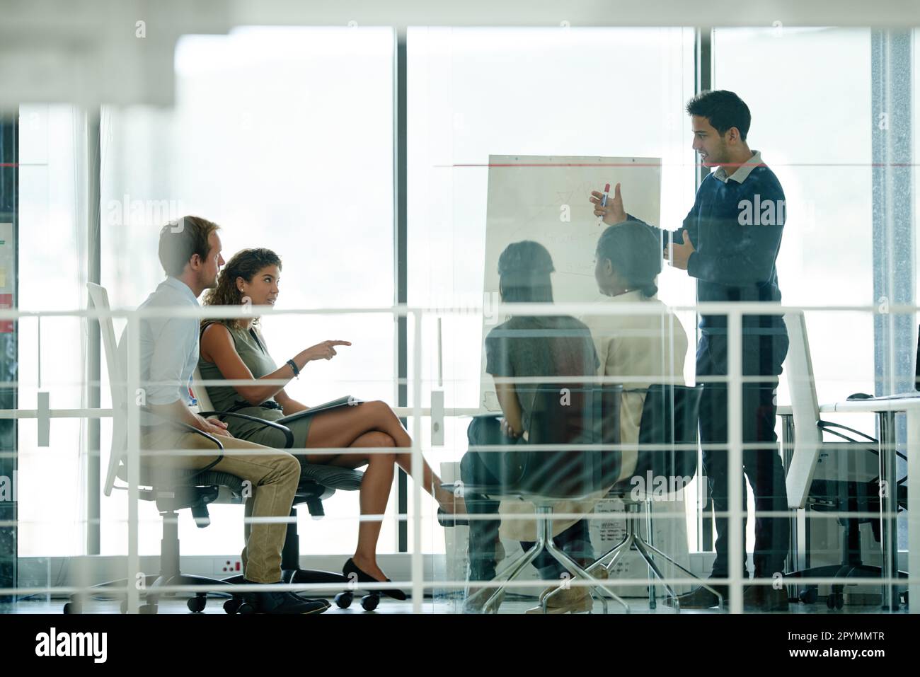 Questions are encourage. a group of colleagues brainstorming in an ...