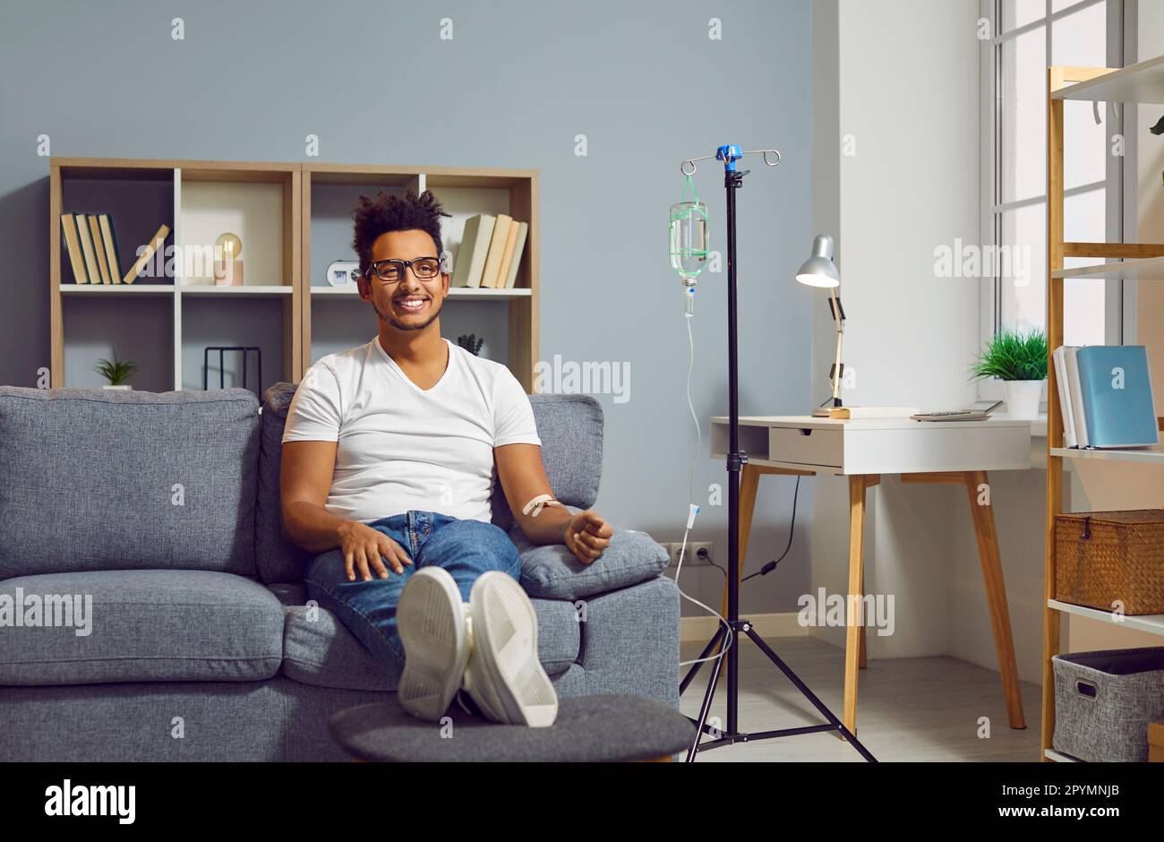 Young happy african american man receiving IV drip infusion and vitamin ...