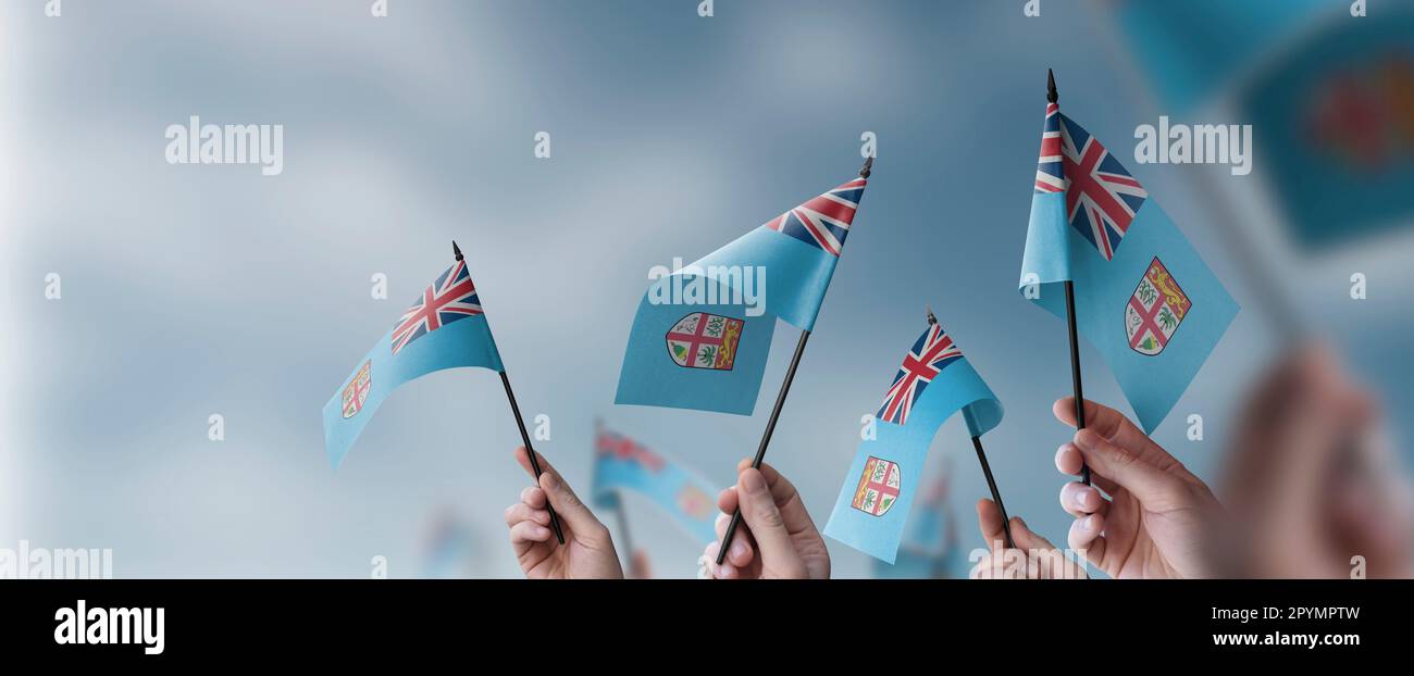 A group of people holding small flags of the Fiji in their hands Stock ...