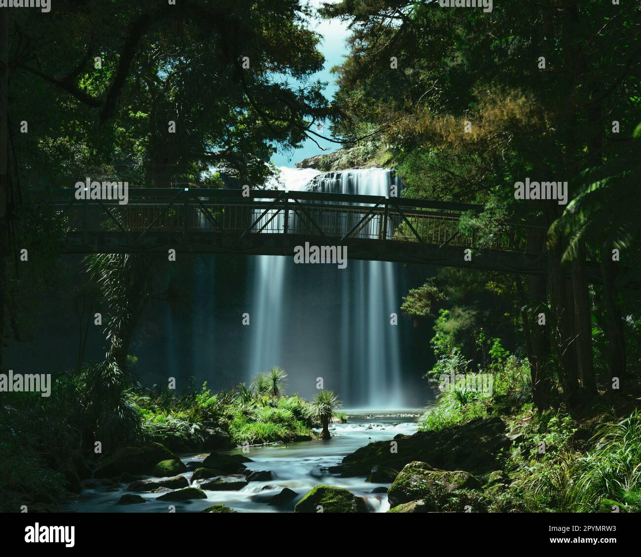 A scenic view of a bridge overlooking a powerful waterfall cascading ...