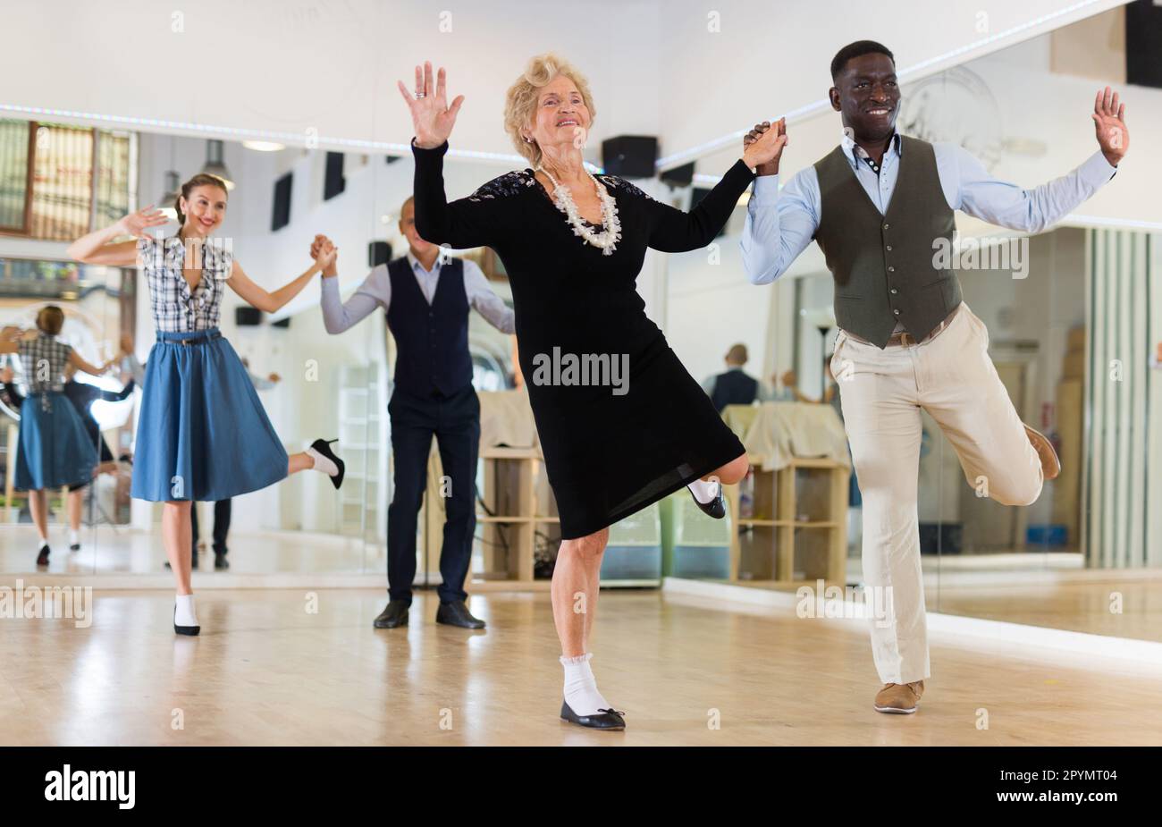 Man and elderly woman performing jazz dance in dancing room Stock Photo ...