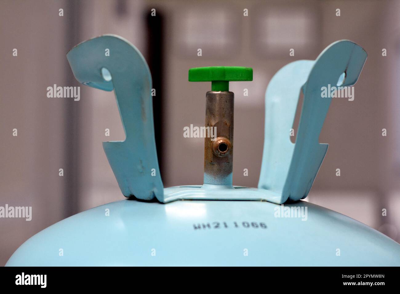 A Freon gas cylinder filled with colorless gas at room temperature ...