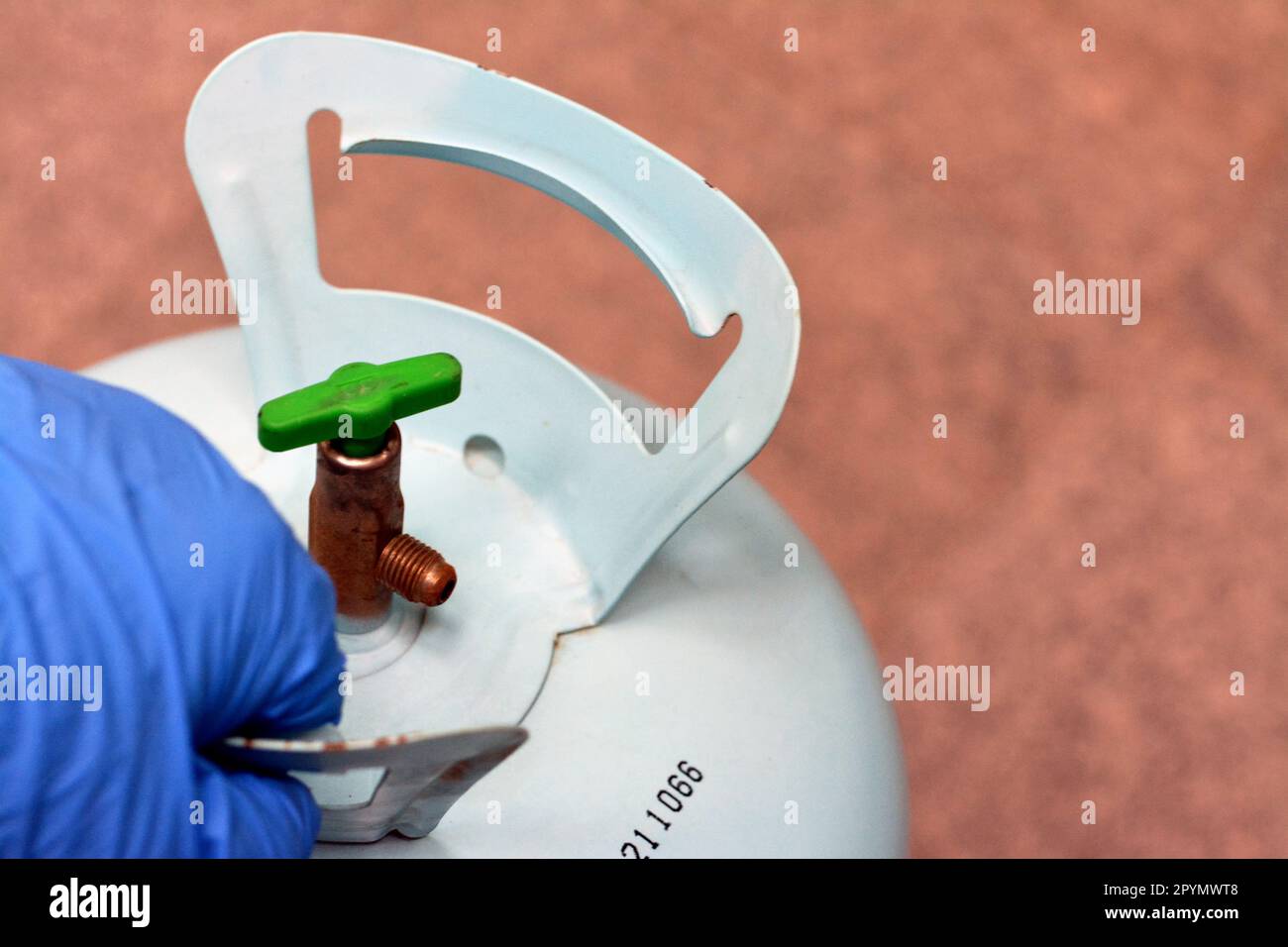 A Freon gas cylinder filled with colorless gas at room temperature ...