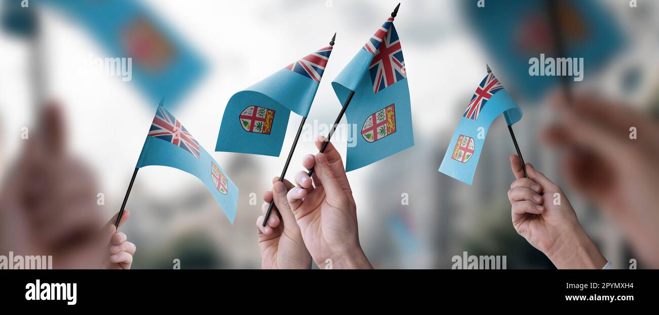 A group of people holding small flags of the Fiji in their hands Stock ...