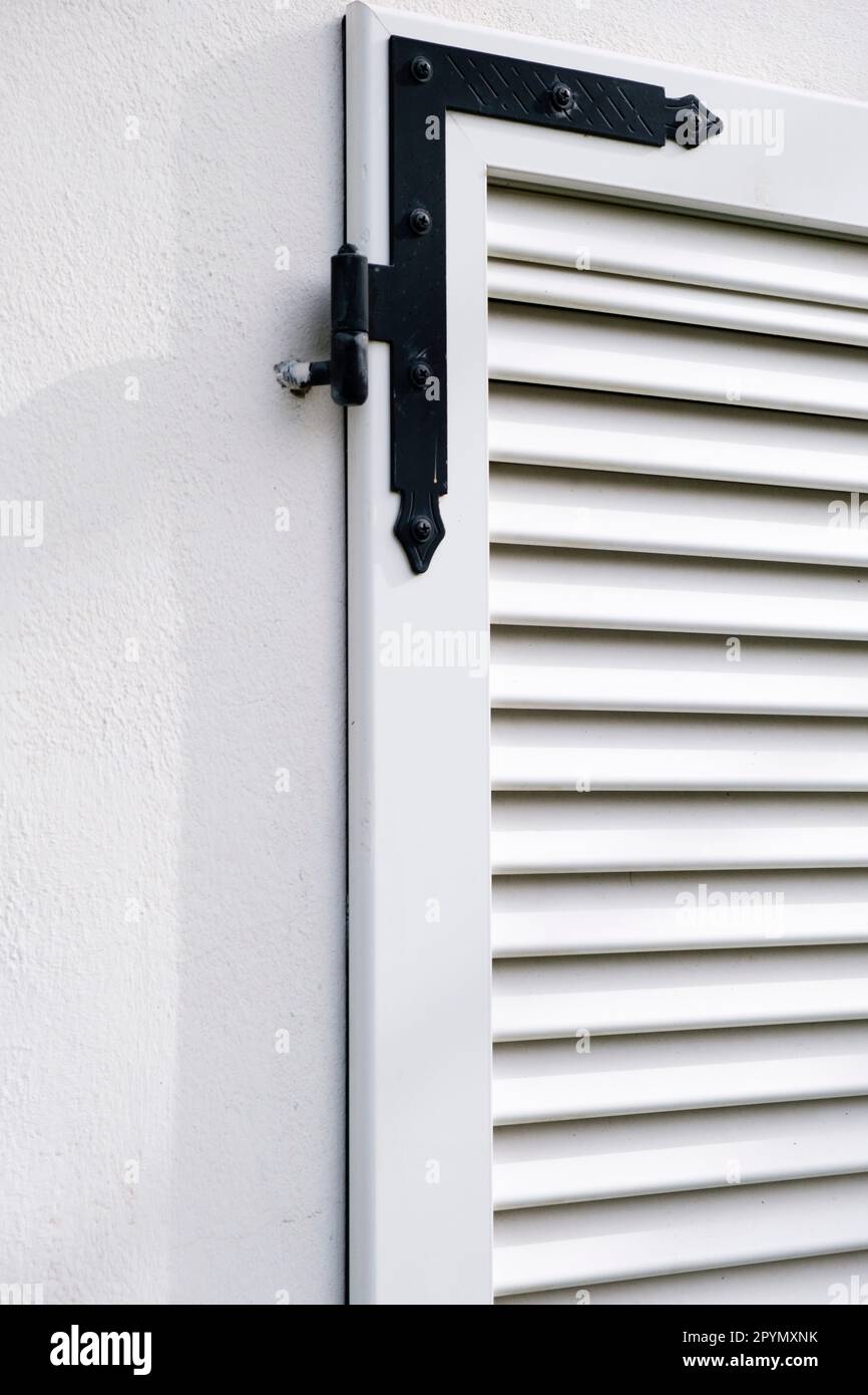 A closed white shutter over a window Stock Photo - Alamy