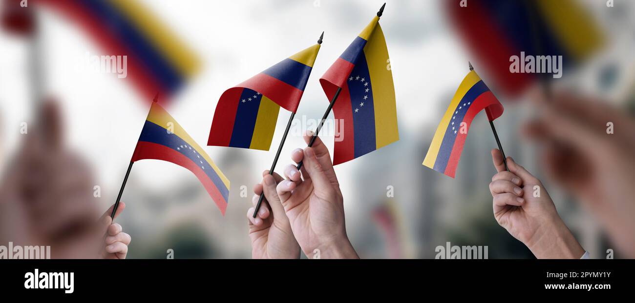 A group of people holding small flags of the Venezuela in their hands ...