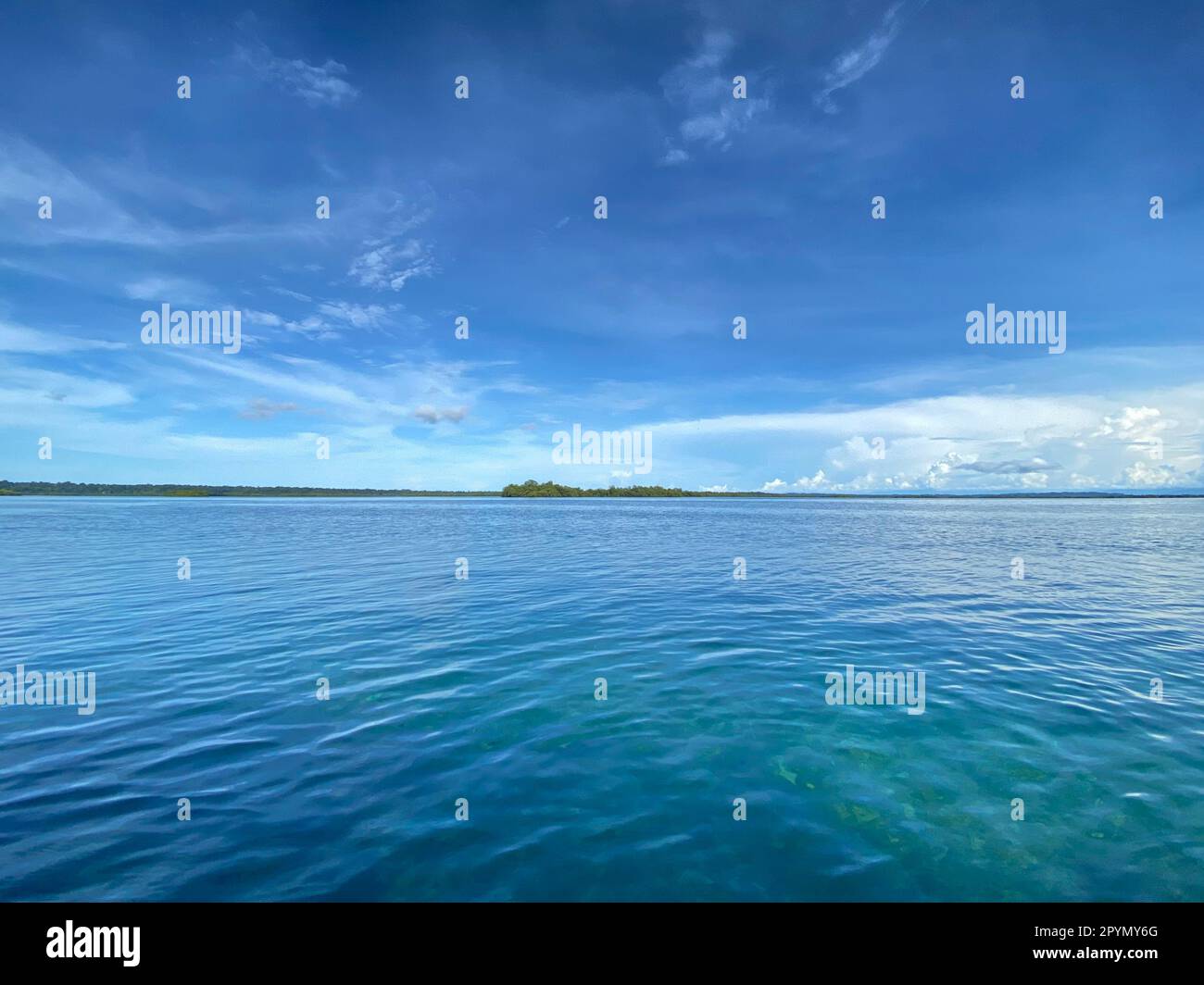 This tranquil scene depicts a picturesque view of an ocean, with ...