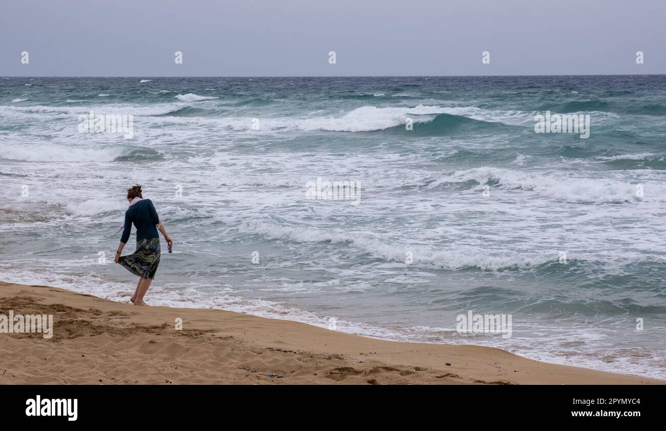 Unrecognised person walking in a tropical sandy beach. Outdoor activity ...
