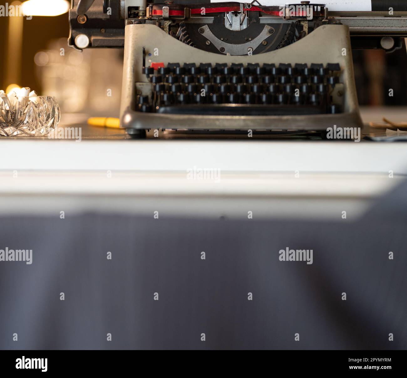 Old-fashioned typewriter on desk with ashtray and blurry jacket Stock ...