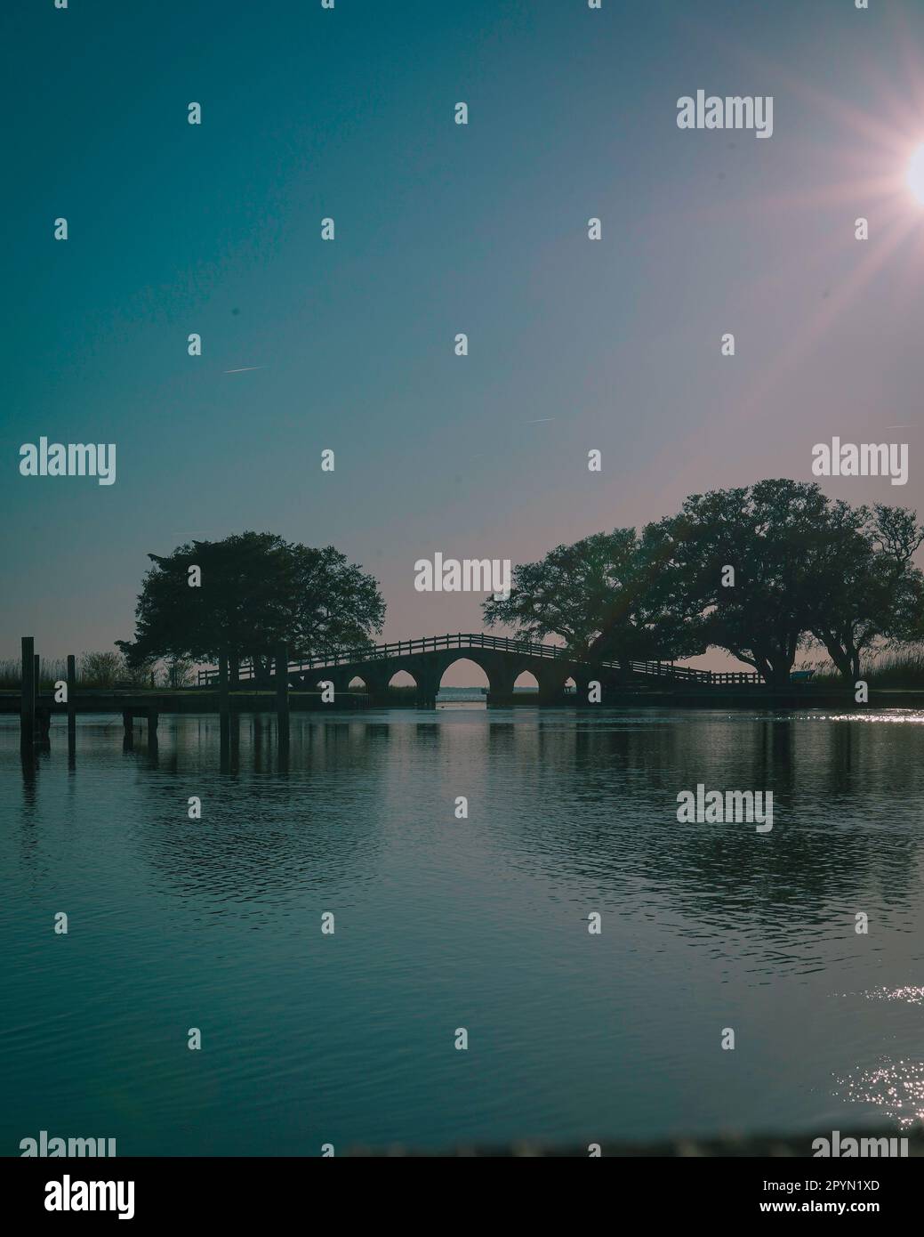 A scenic view of a bridge in the distance with a body of water and ...