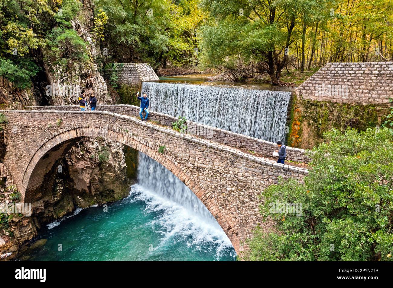 The old stone, arched bridge, between two waterfalls in Palaiokaria ...