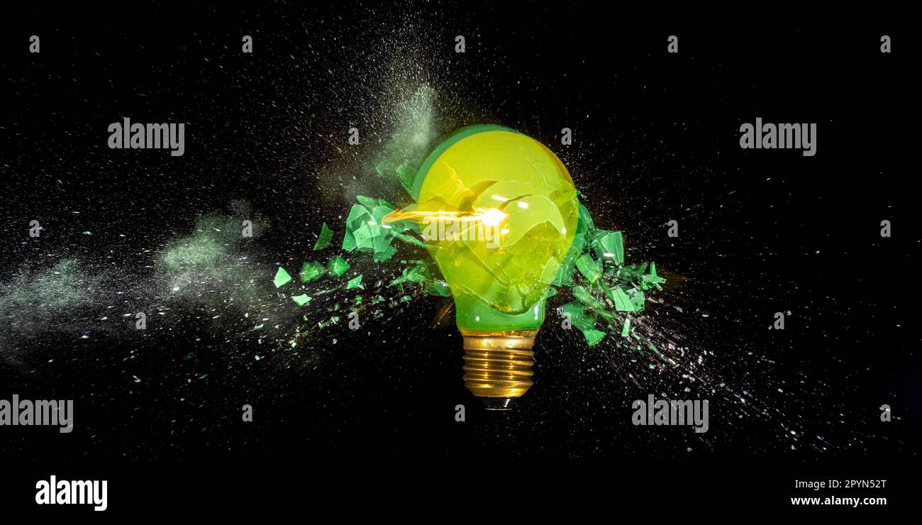 green bulb breaks into a thousand pieces background Stock Photo - Alamy