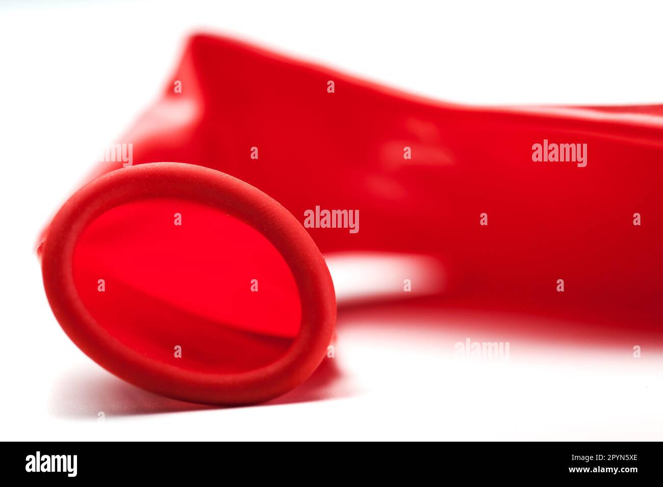 Deflated red balloon isolated on white background. Abstract close up ...