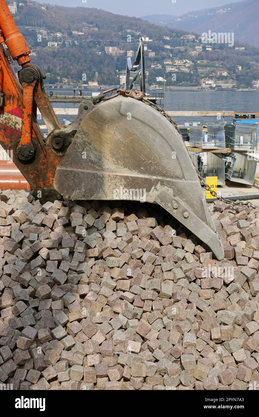 digger bucket and heap of porphyry paving stones Stock Photo - Alamy