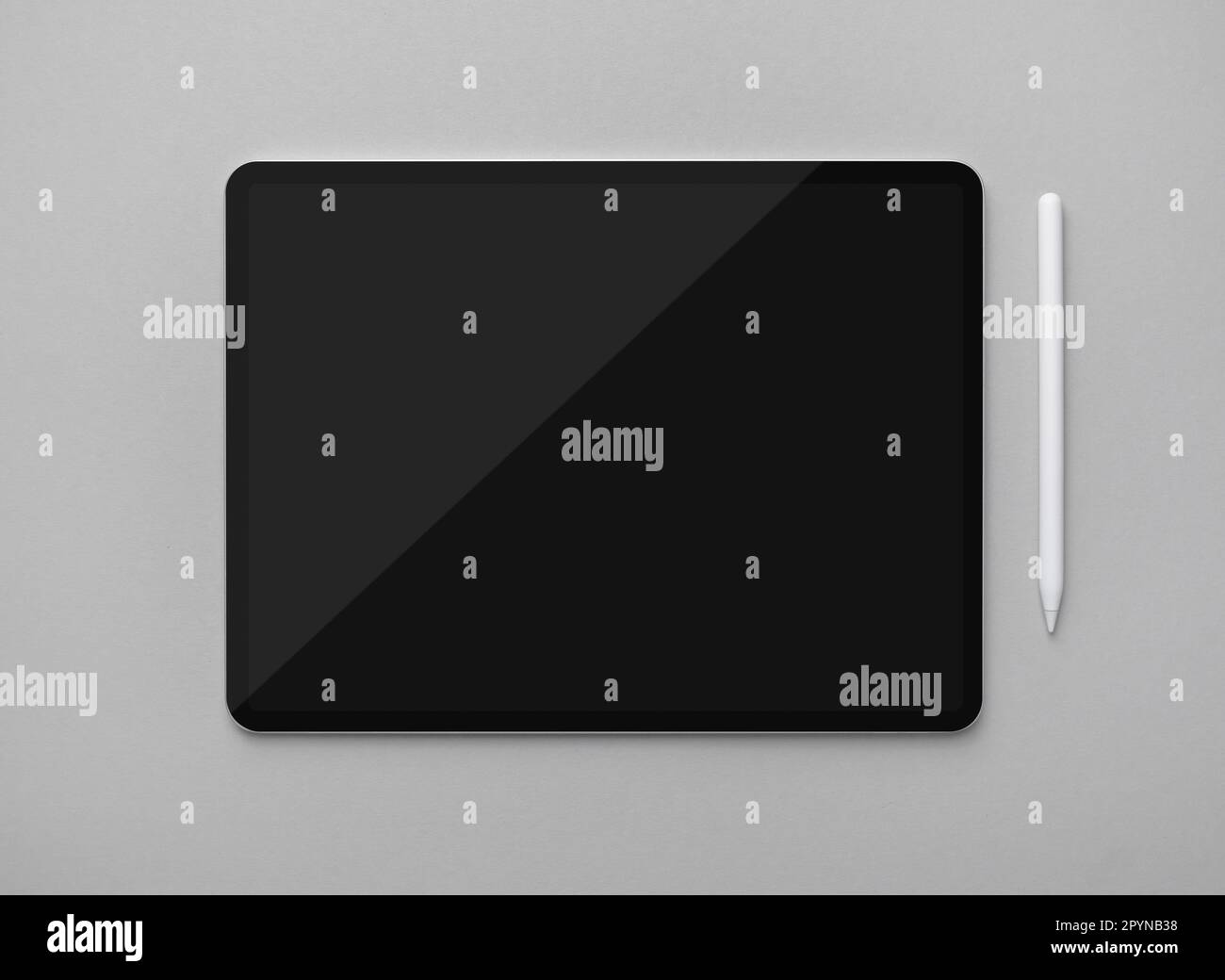 Mockup of tablet computer with blank black screen and stylus on gray ...