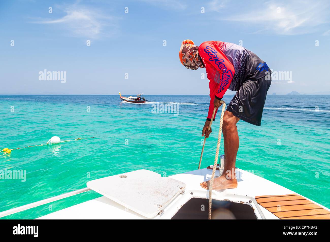 Thailand, Phuket - 01.04.23: A sailor on a speedboat manages the ...