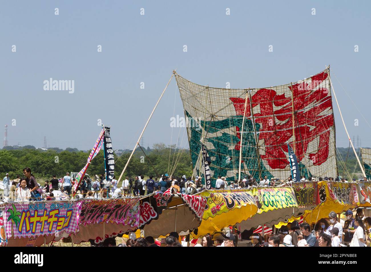 A large kite on display above food and entertainment stalls at the ...