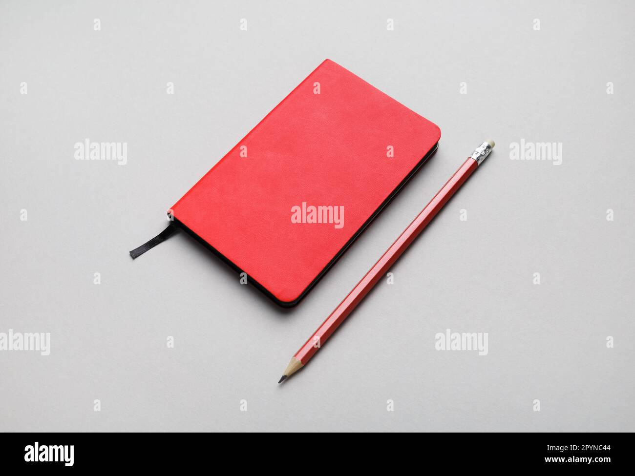 Blank red notepad and pencil on gray paper background. Blank branding ...