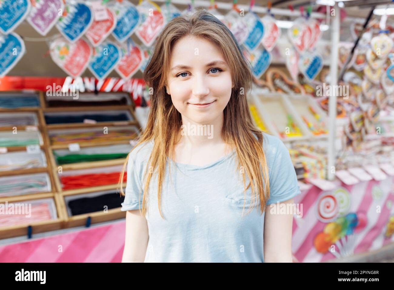 Happy young Gen Z woman in an amusement park, smiling. Copy space ...