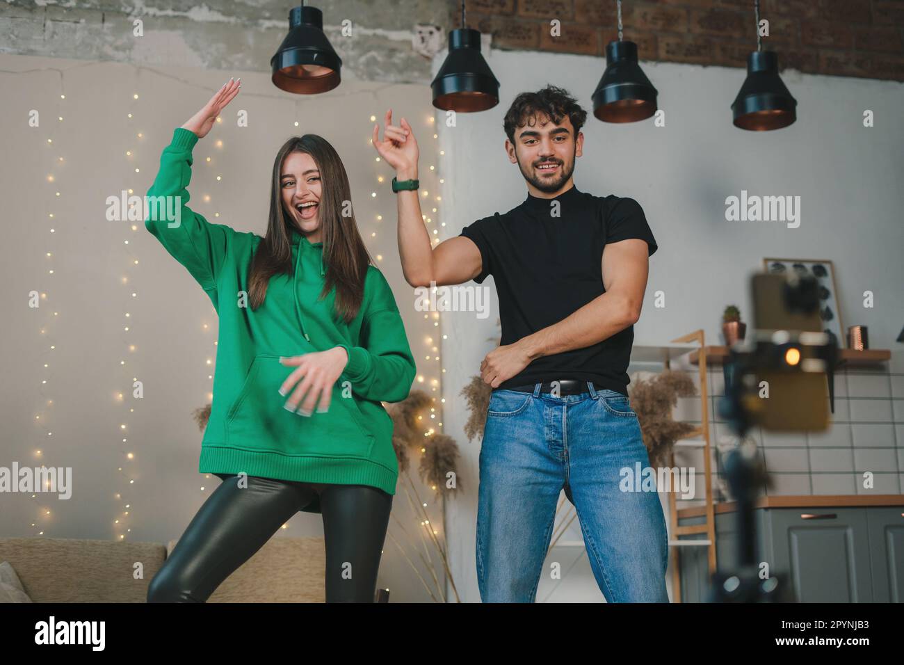 Two persons of generation z friends doing trendy dance moves in front ...