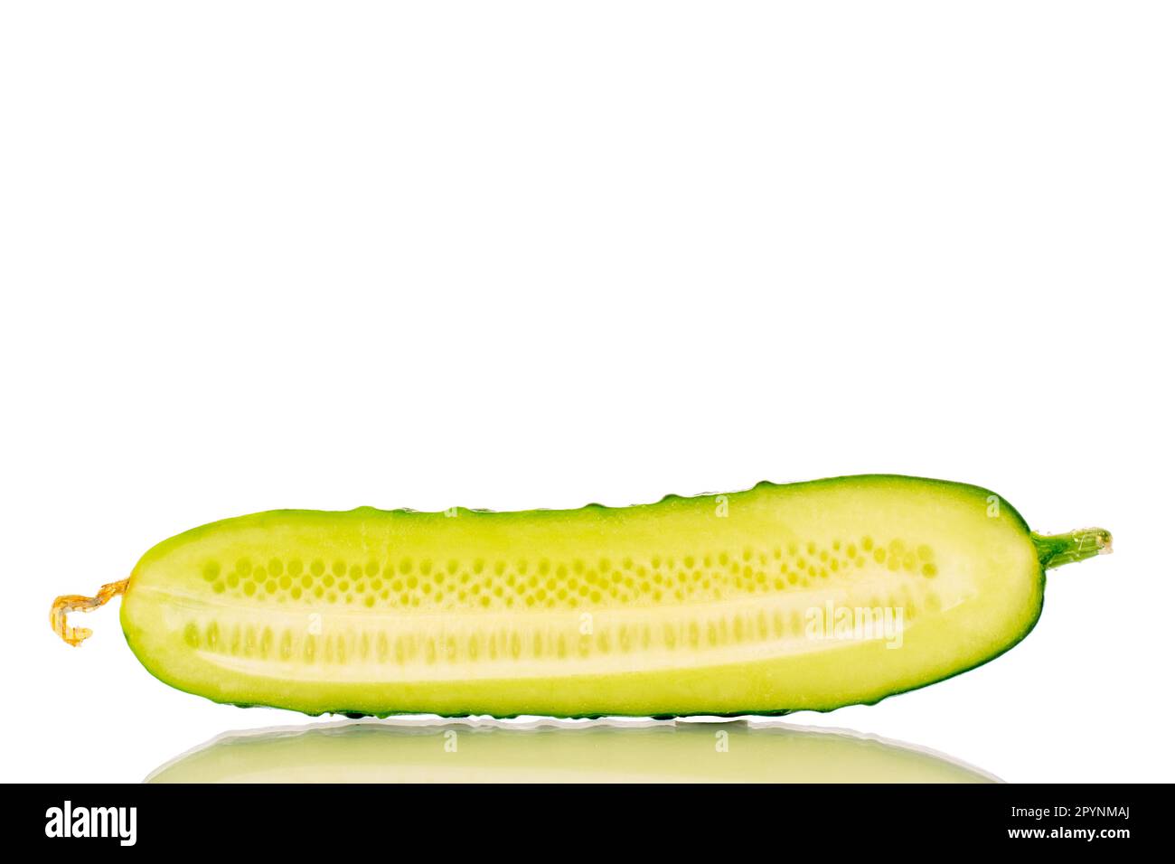 One half of a ripe gherkin cucumber, macro, isolated on white ...