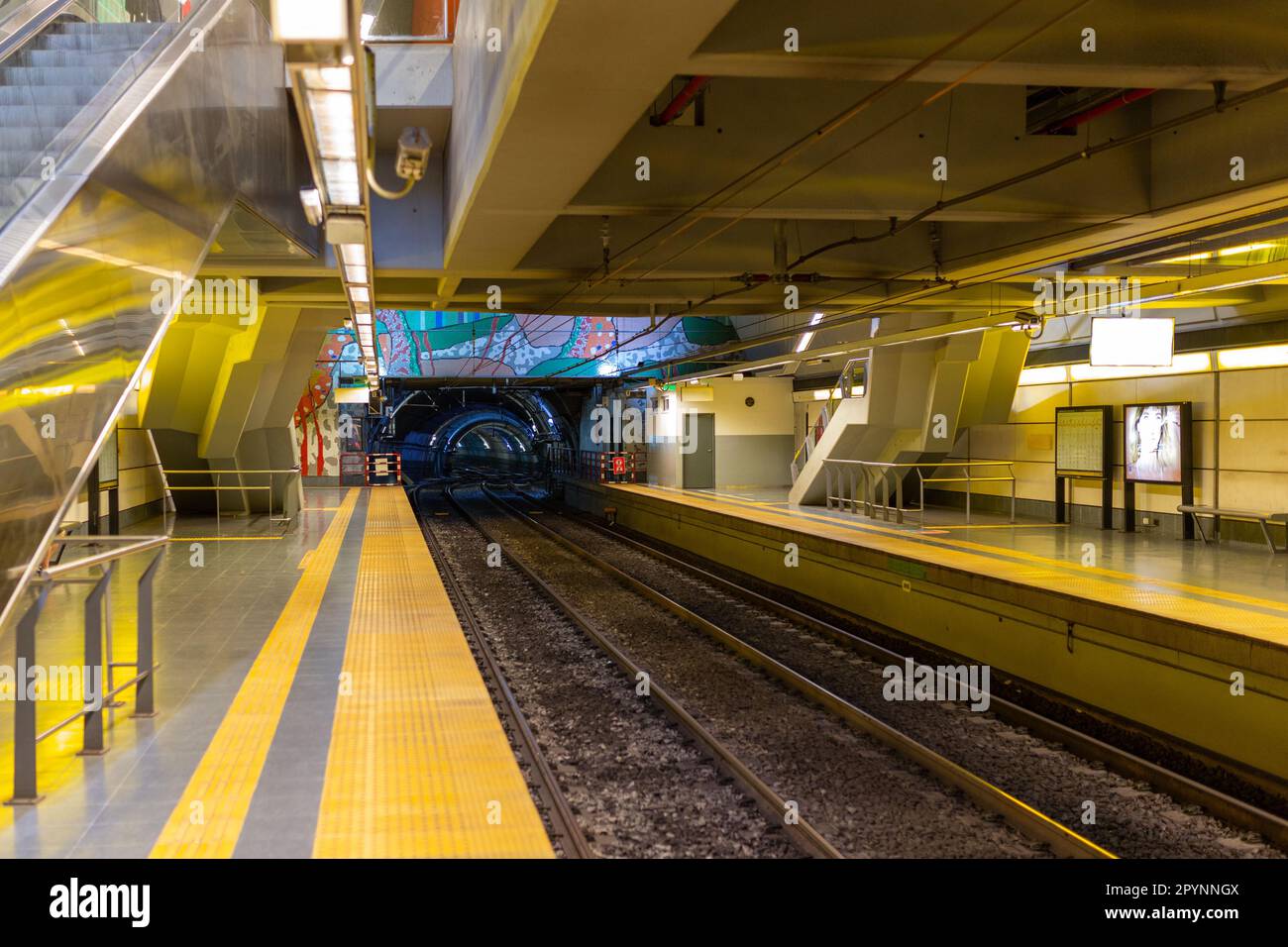 metro station with tunnel rails and escalator Stock Photo - Alamy