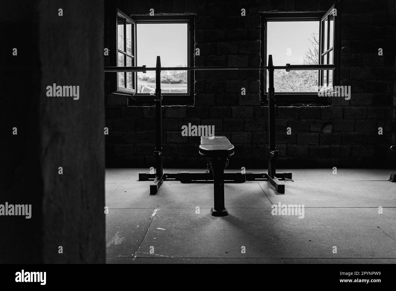 A grayscale of a home gym with stone walls Stock Photo - Alamy