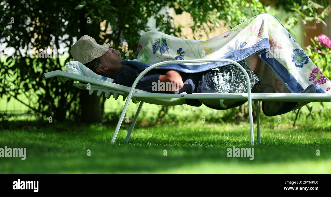 Candid older man taking a break resting outside preparing to sleep ...