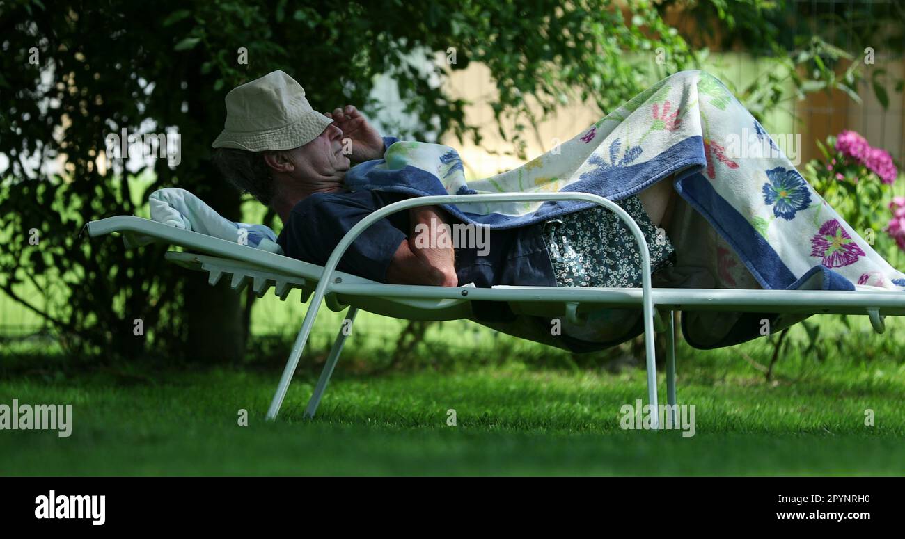 Candid older man taking a break resting outside preparing to sleep ...