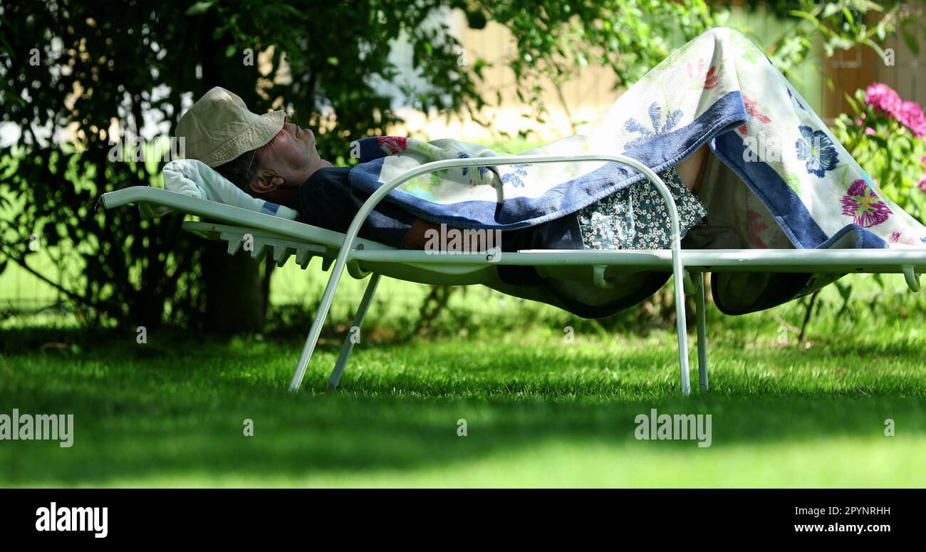 Candid older man taking a break resting outside preparing to sleep ...