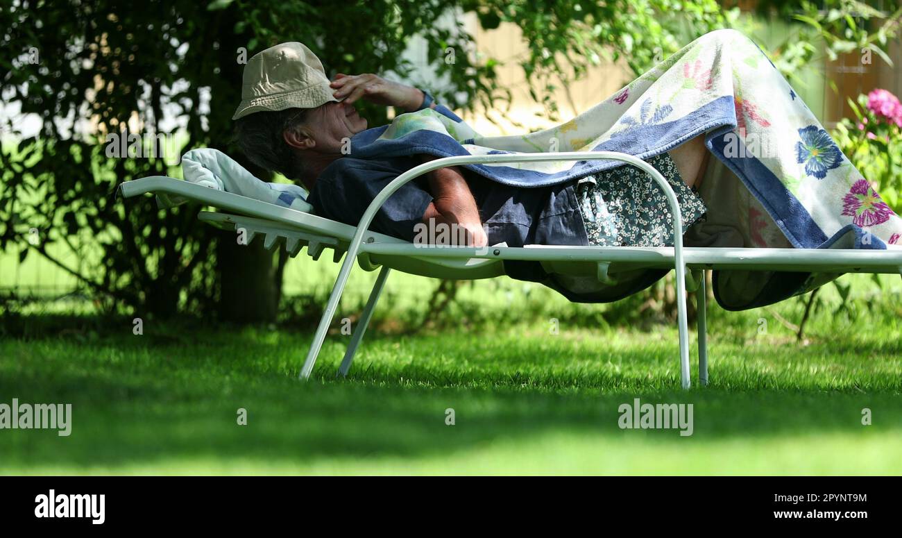 Candid older man taking a break resting outside preparing to sleep ...