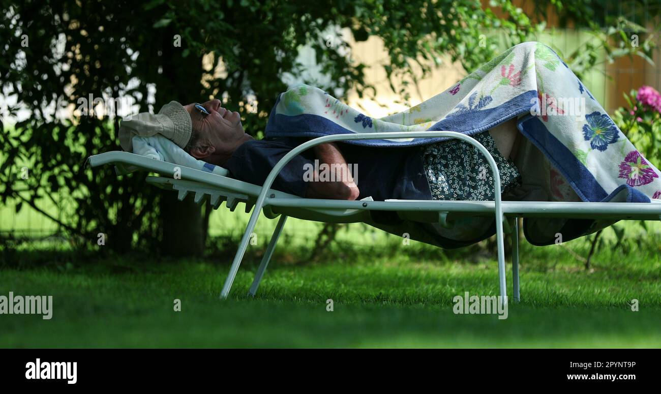 Candid older man taking a break resting outside preparing to sleep ...