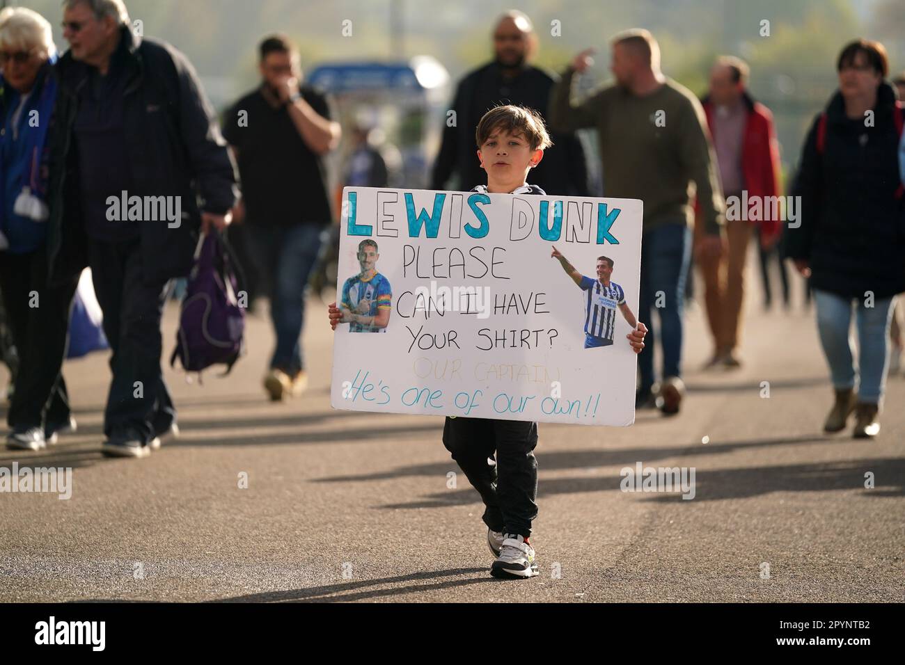 A young Brighton and Hove Albion fan with a Lewis Dunk sign outside the ...