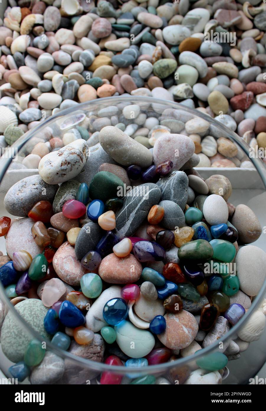 Round glass vase with colored minerals and flat box with sea stones top ...