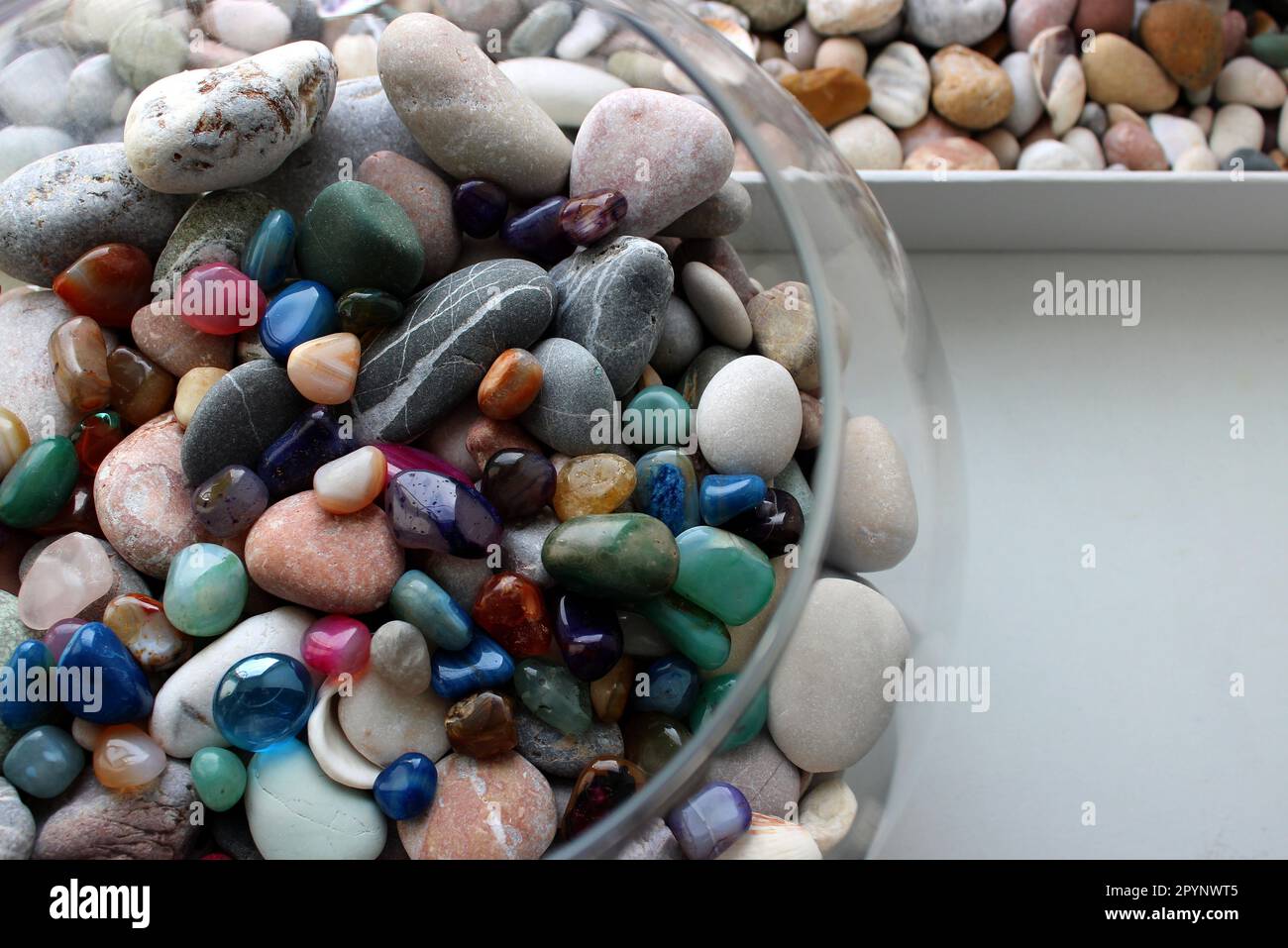 Round glass sphere filled with semi-precious stones next to a box of ...