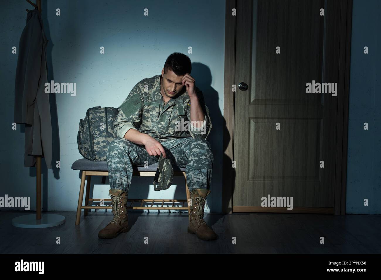 Depressed military veteran sitting in hallway on bench at night,stock ...