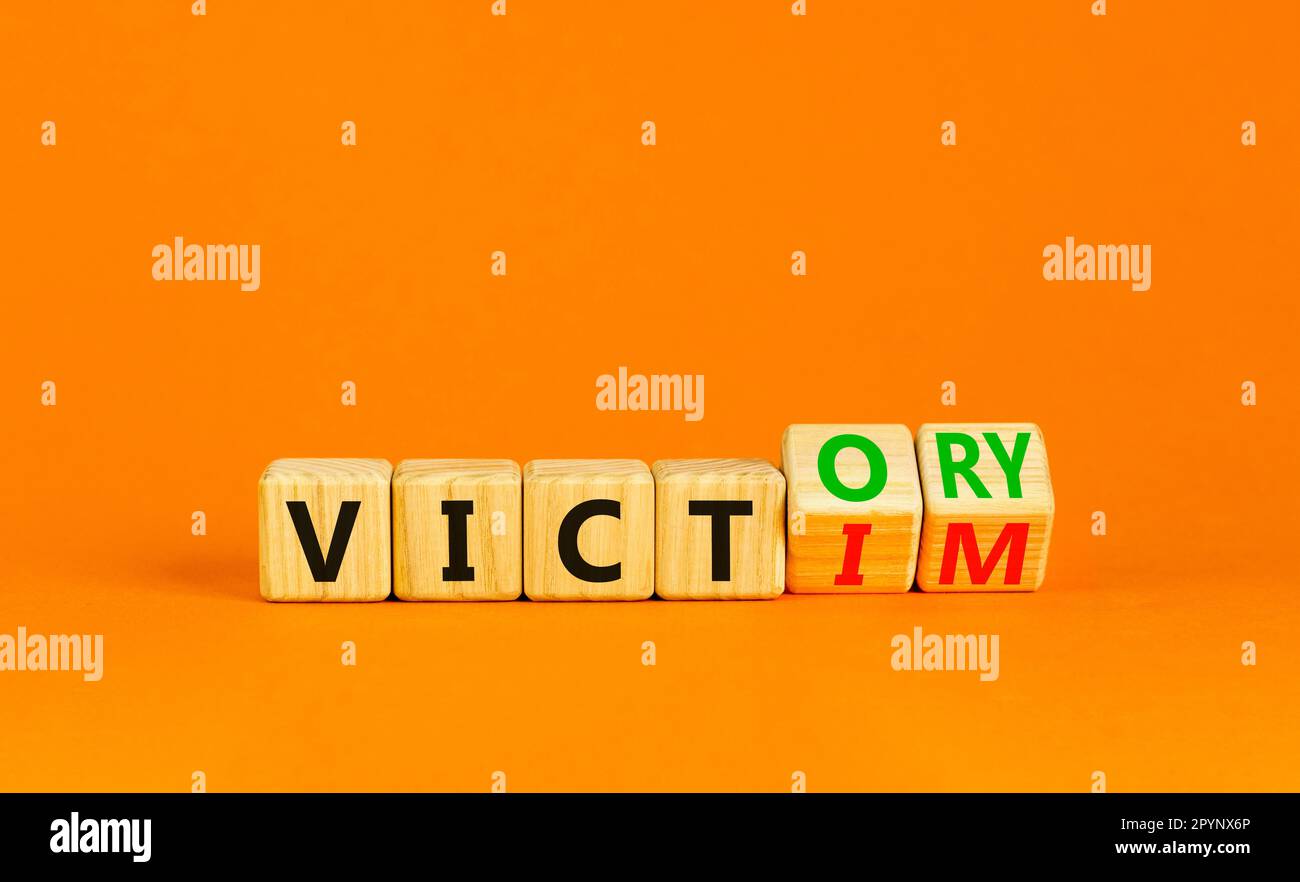 From victim to victory symbol. Businessman turns wooden cubes and ...