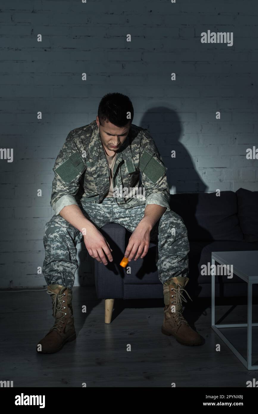 Soldier in uniform holding antidepressants while suffering from ...