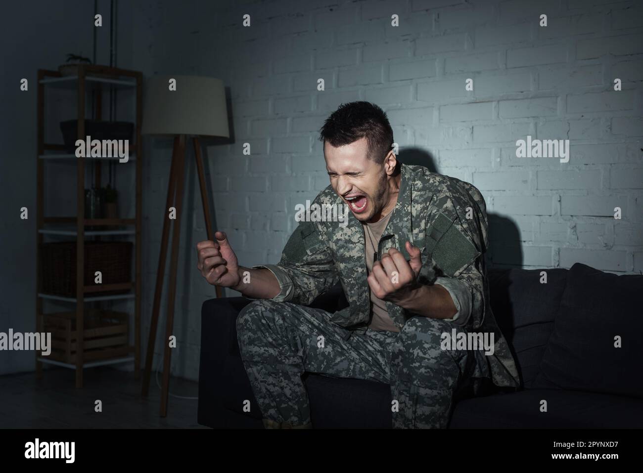 Angry soldier with post traumatic stress disorder screaming on couch at ...